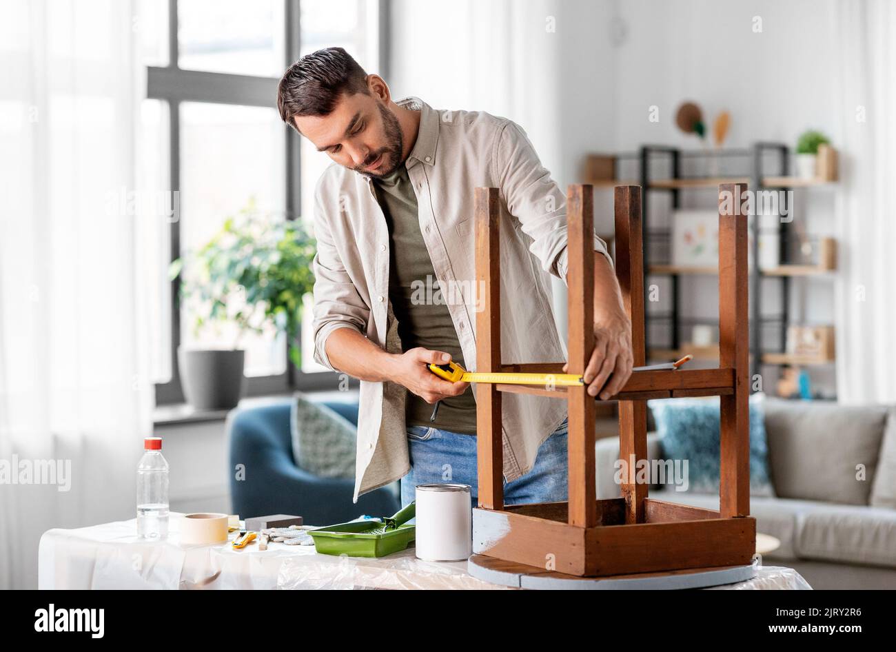 man with ruler measuring table for renovation Stock Photo - Alamy