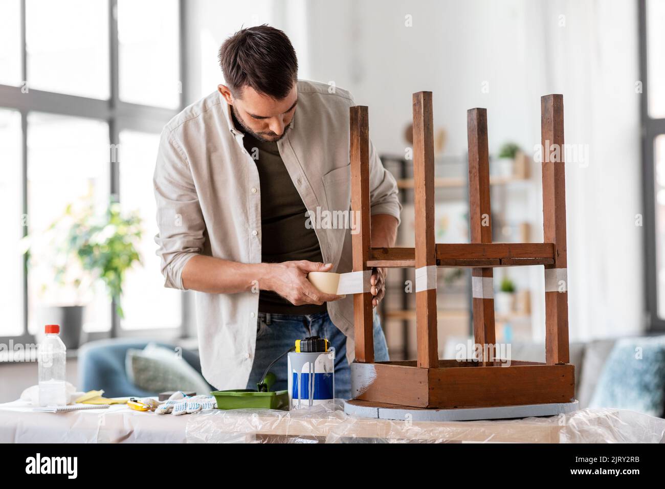 man sticking adhesive tape to table for repainting Stock Photo - Alamy