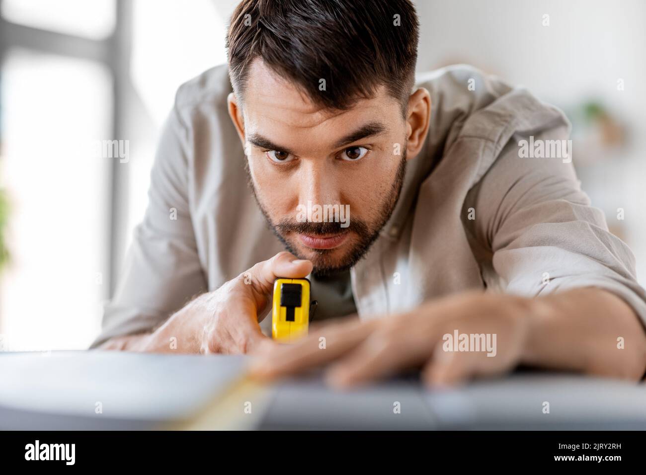 man with ruler measuring table for renovation Stock Photo - Alamy