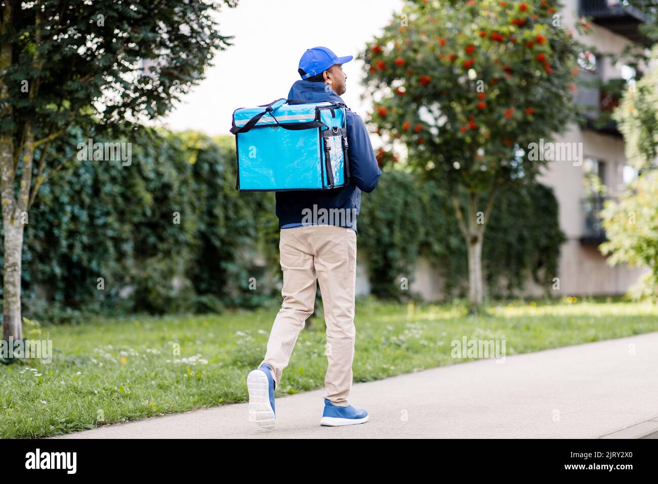 indian delivery man with bag walking in city Stock Photo - Alamy