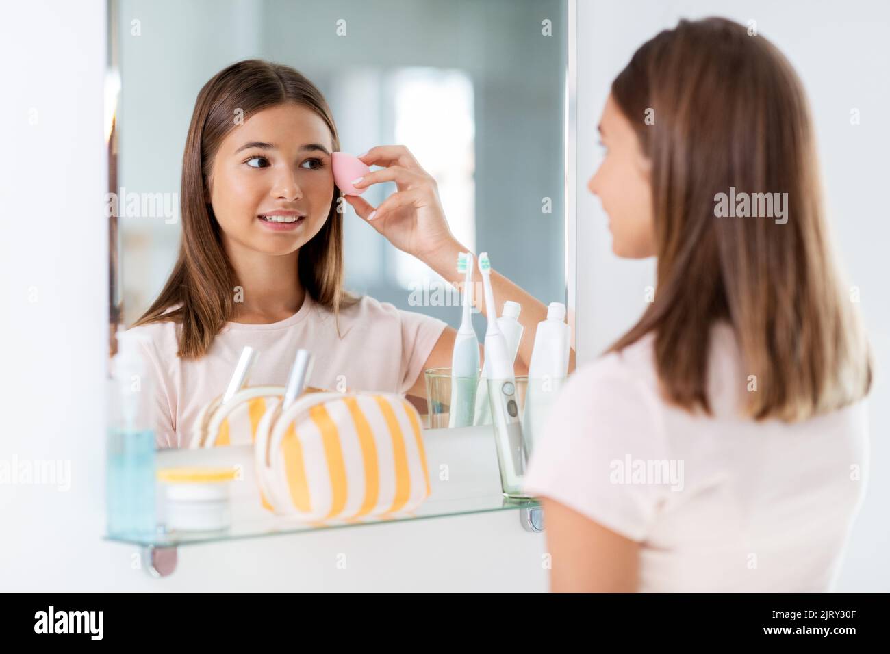 teenage girl applying foundation to face Stock Photo - Alamy