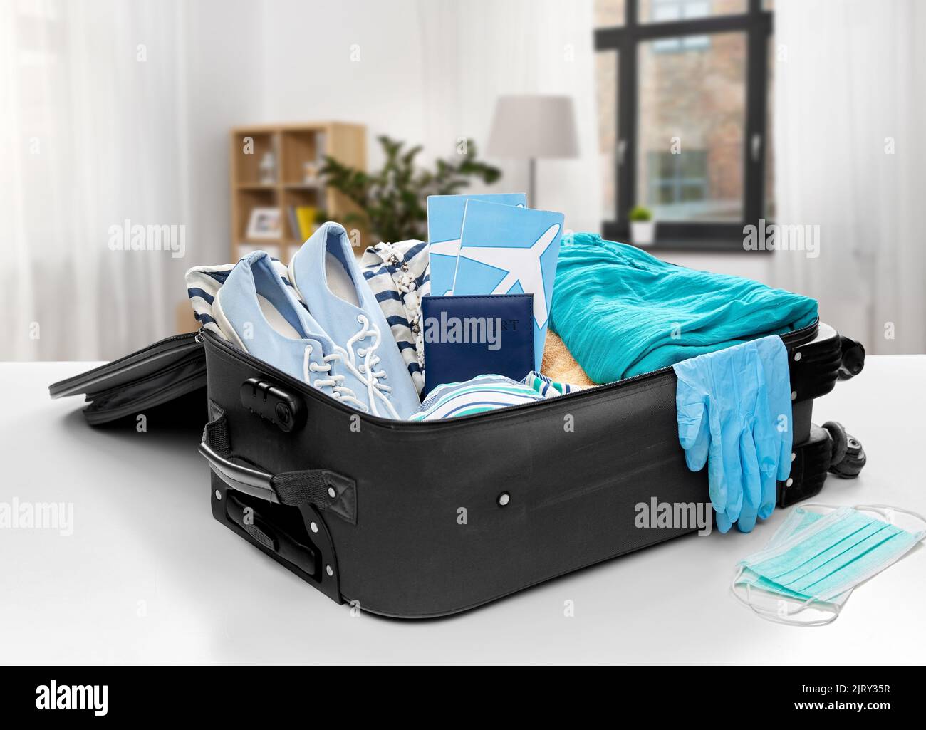 travel bag packed with clothes, gloves and masks Stock Photo - Alamy