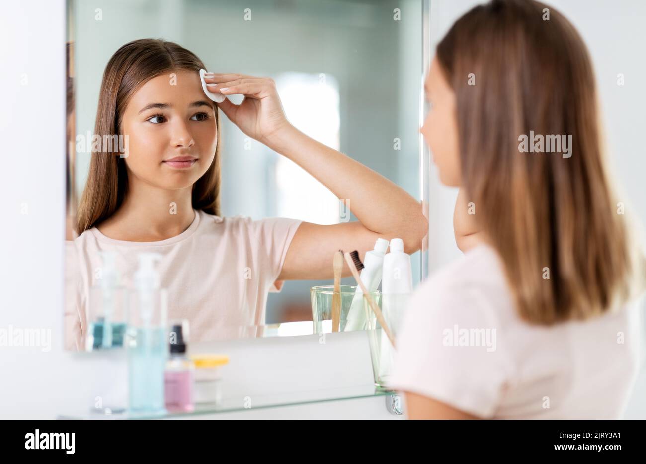 teenage girl cleaning face skin with cotton disc Stock Photo - Alamy