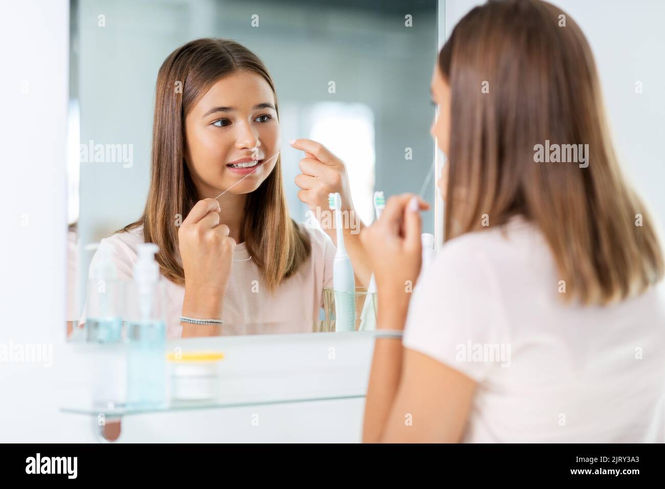 teenage girl with floss cleaning teeth at bathroom Stock Photo - Alamy