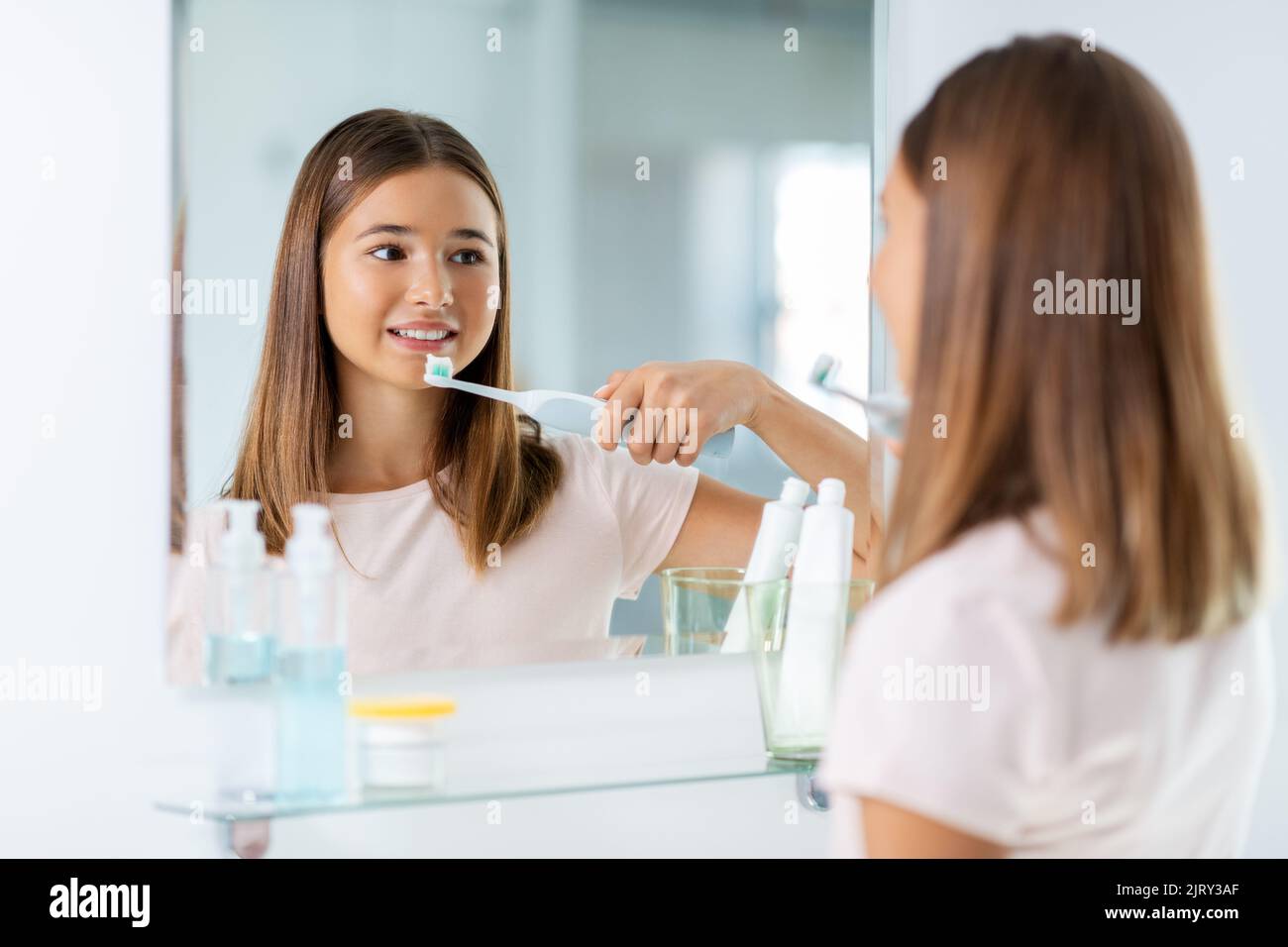 teen girl with electric toothbrush brushing teeth Stock Photo - Alamy