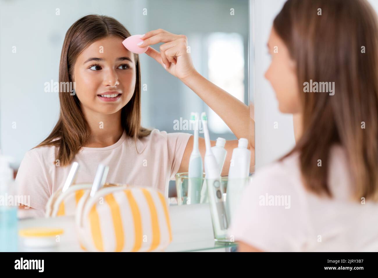 teenage girl applying foundation to face Stock Photo - Alamy