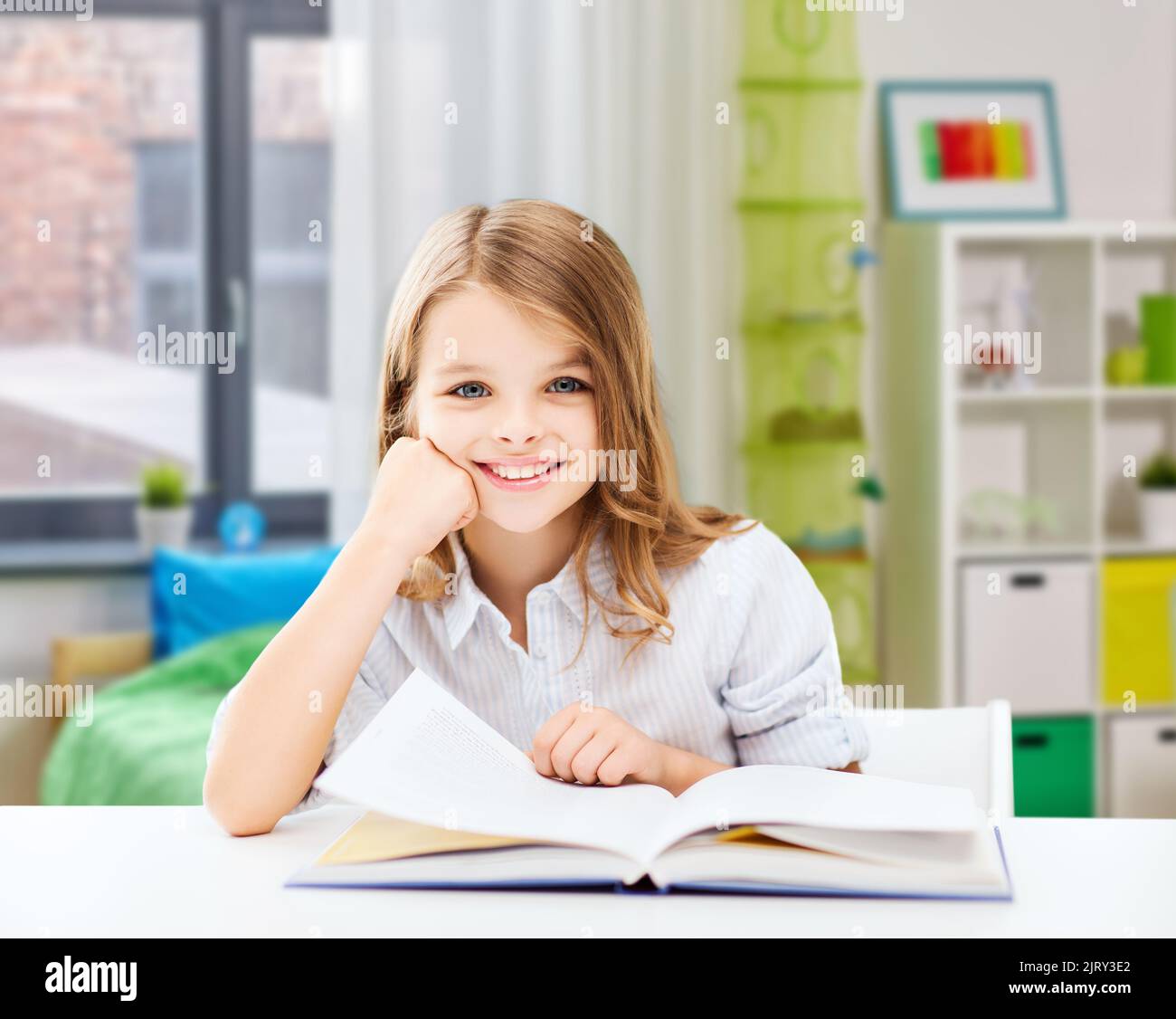 happy smiling student girl reading book at home Stock Photo - Alamy