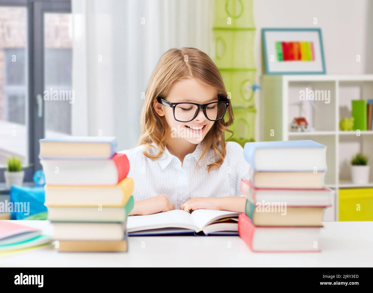 happy smiling student girl reading book at home Stock Photo - Alamy