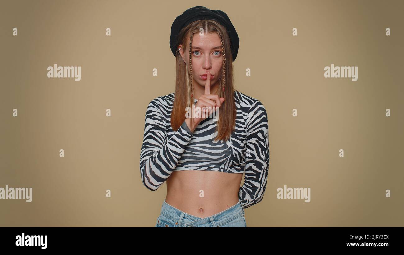 Shh be quiet please. Pretty young scared woman presses index finger to ...