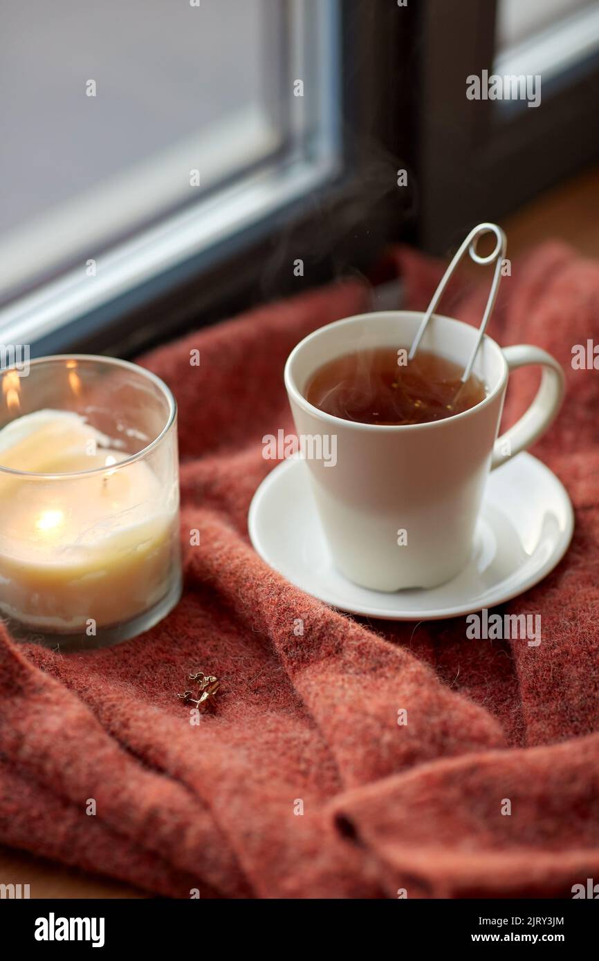cup of tea and candle on window sill Stock Photo - Alamy