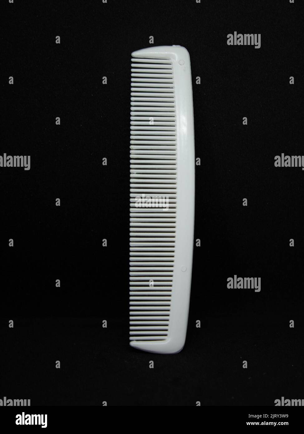 The white plastic comb on black isolated background, vertical Stock ...