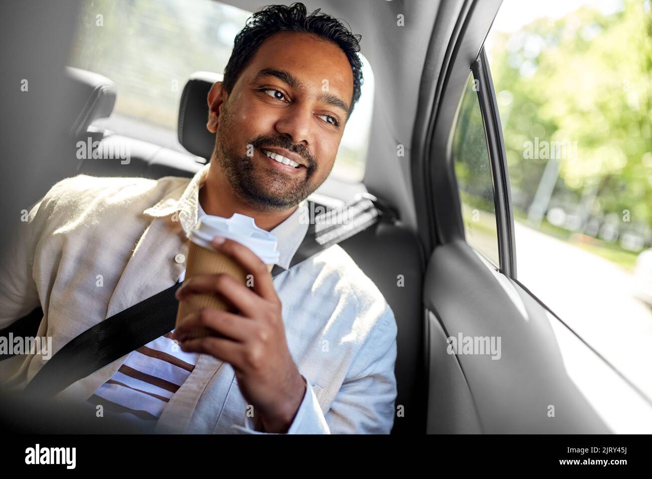 indian man with takeaway coffee on car back seat Stock Photo - Alamy