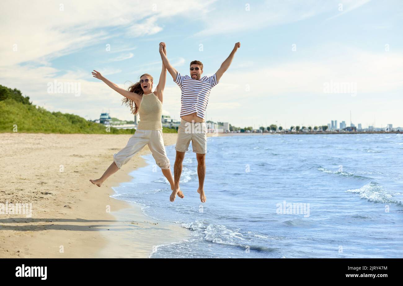 happy couple jumping on summer beach Stock Photo - Alamy