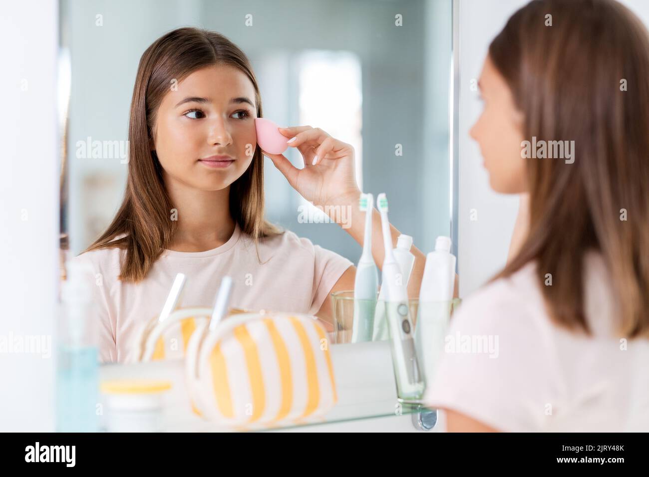 teenage girl applying foundation to face Stock Photo - Alamy