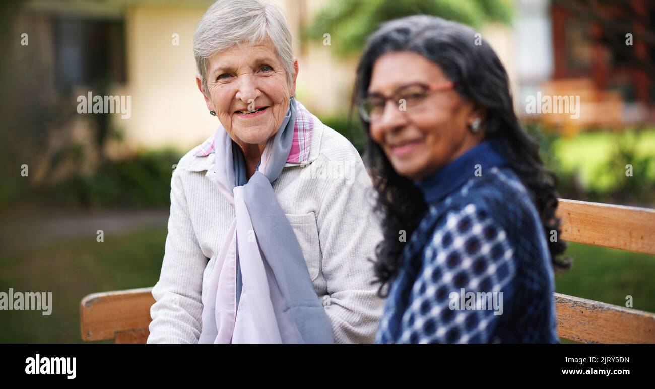 Two old women sitting on bench in park smiling happy life long friends ...