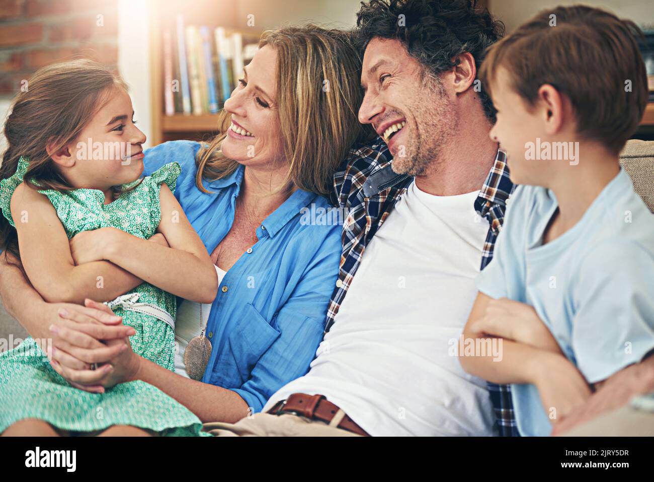 Quality time strengthens family ties. a happy family relaxing on the sofa together at home Stock ...