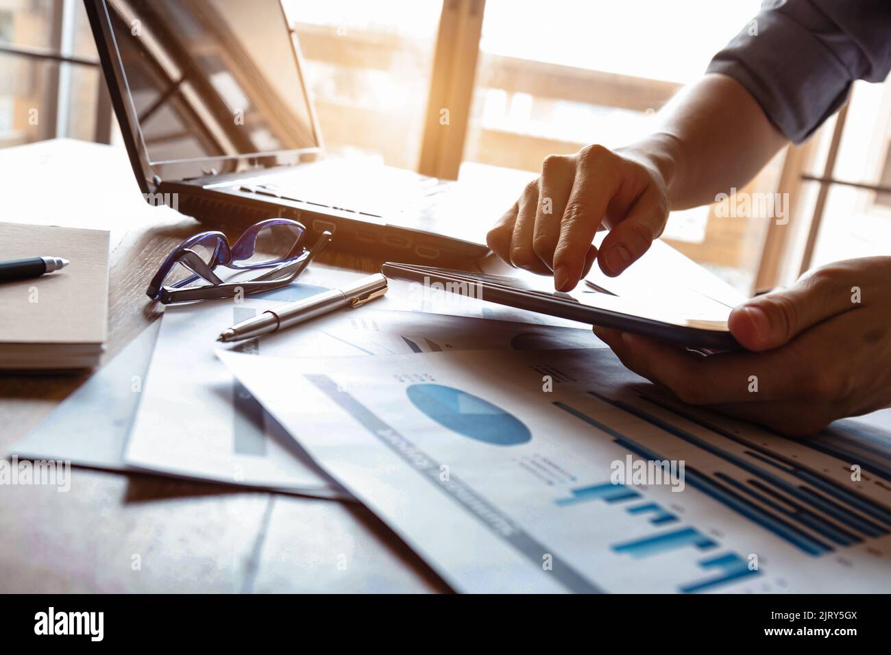 business man analyzing graph and chart document on office desk Stock ...