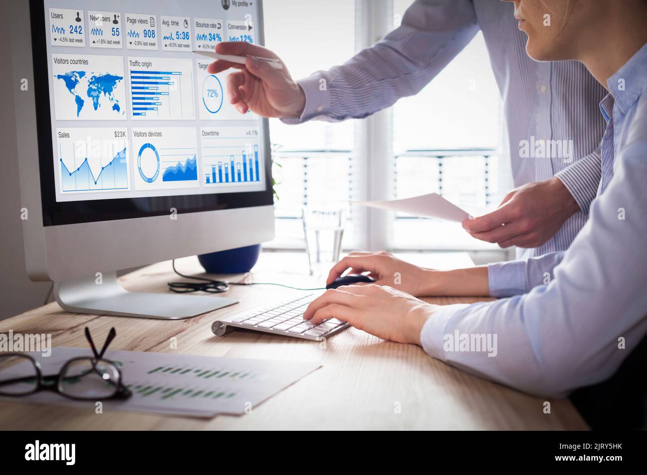 Team of business people discussing digital marketing metrics report and return on investment ...