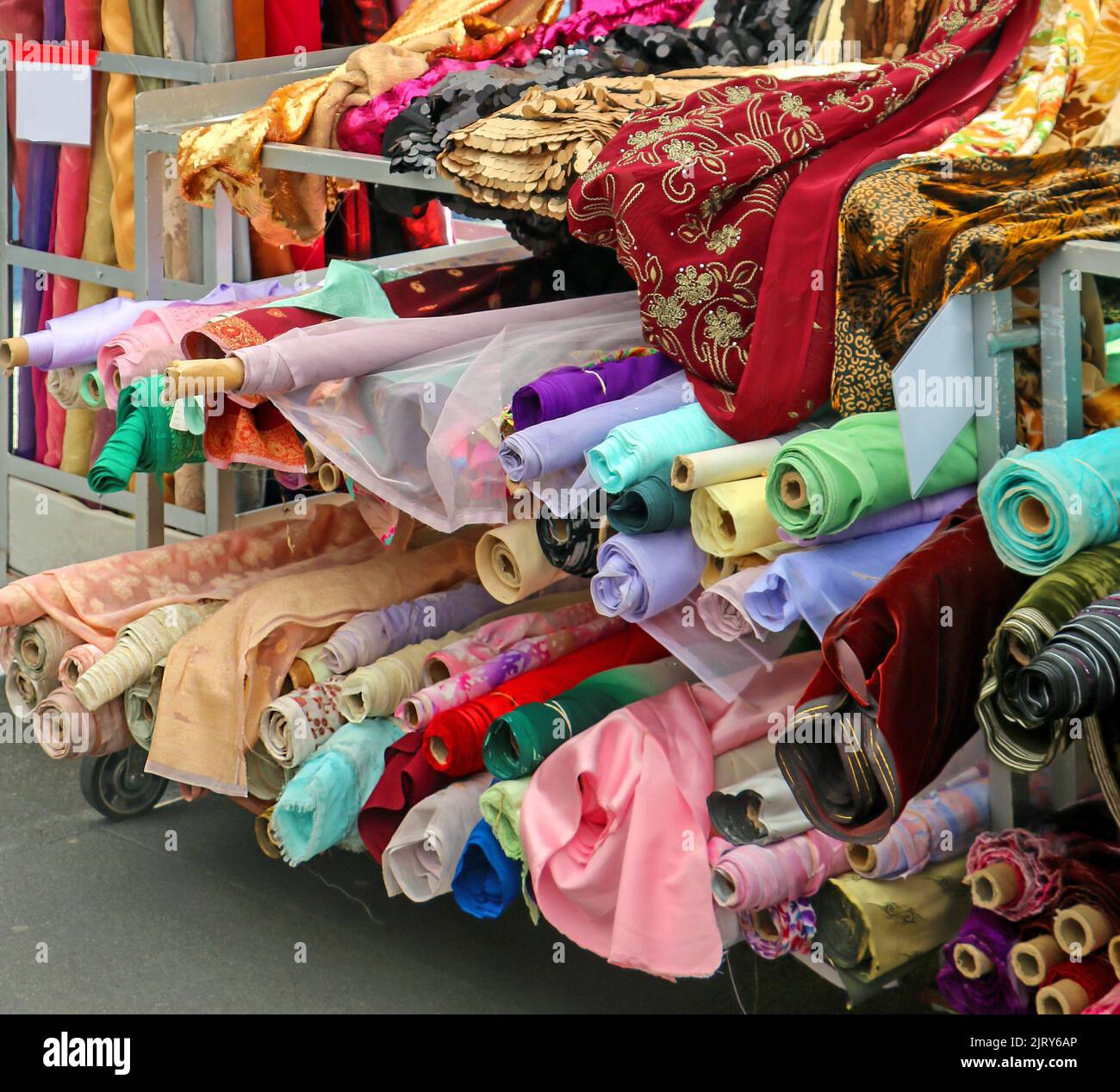 Colorful tubes pile of fashion fabric materials sold on outside market ...