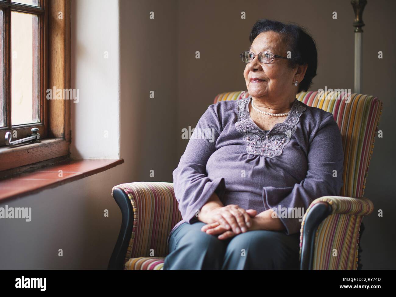 Happy elderly woman looking out window thinking of memories pensioner ...