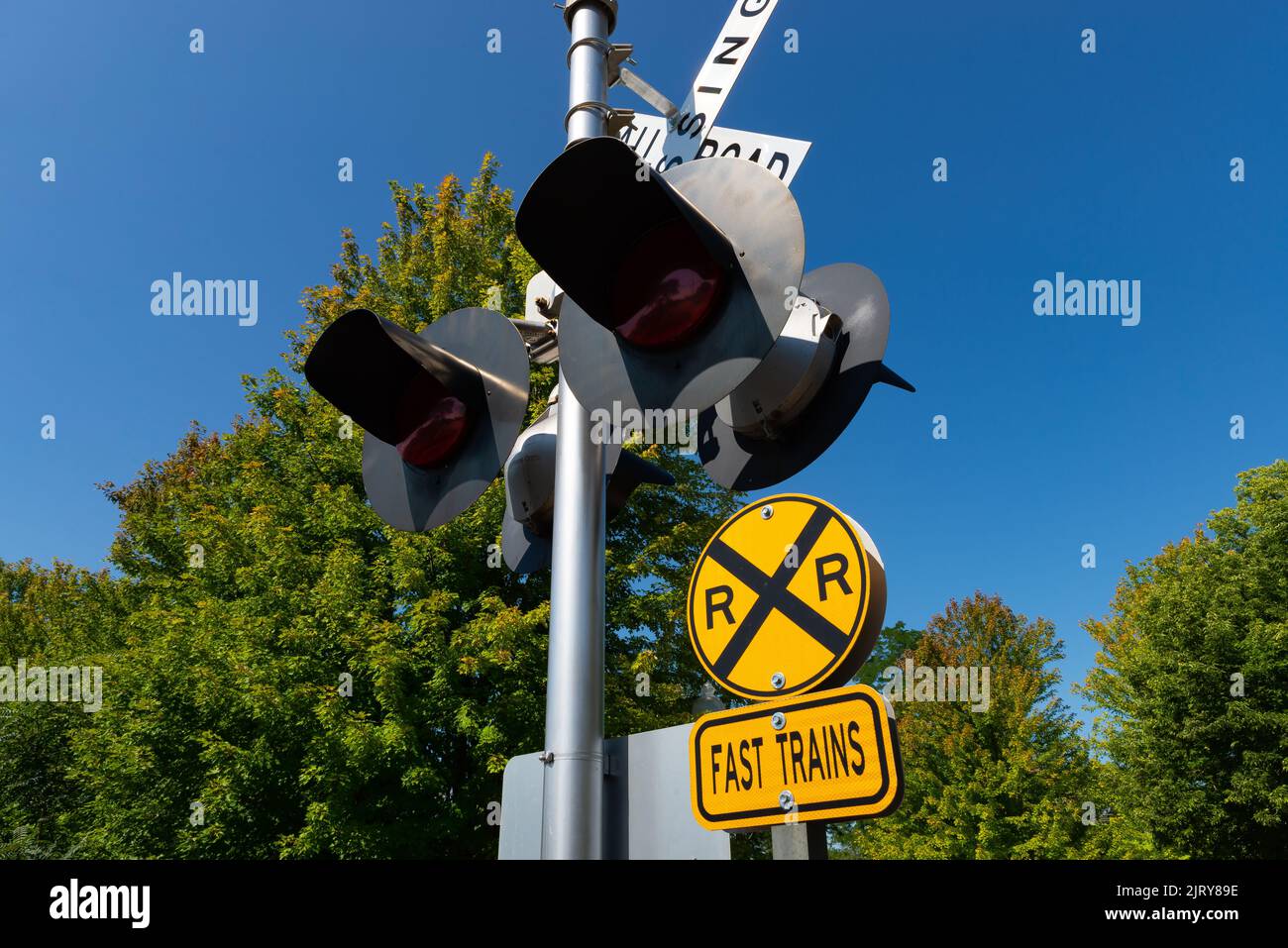 Railroad crossing sign with brilliant blue skies in the background ...