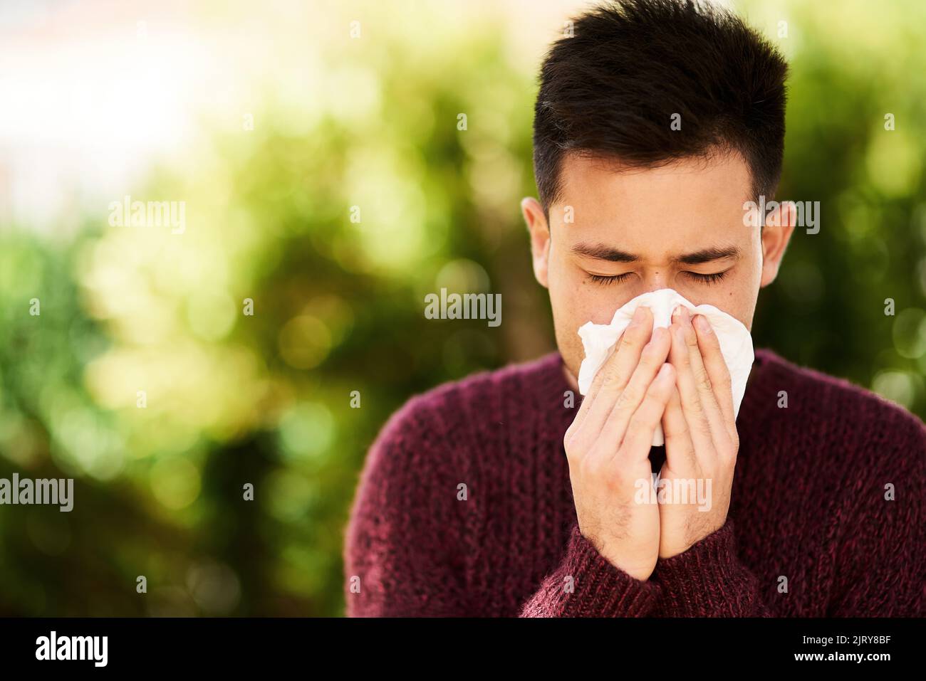 In the fight against flu. a young man blowing his nose outside Stock ...