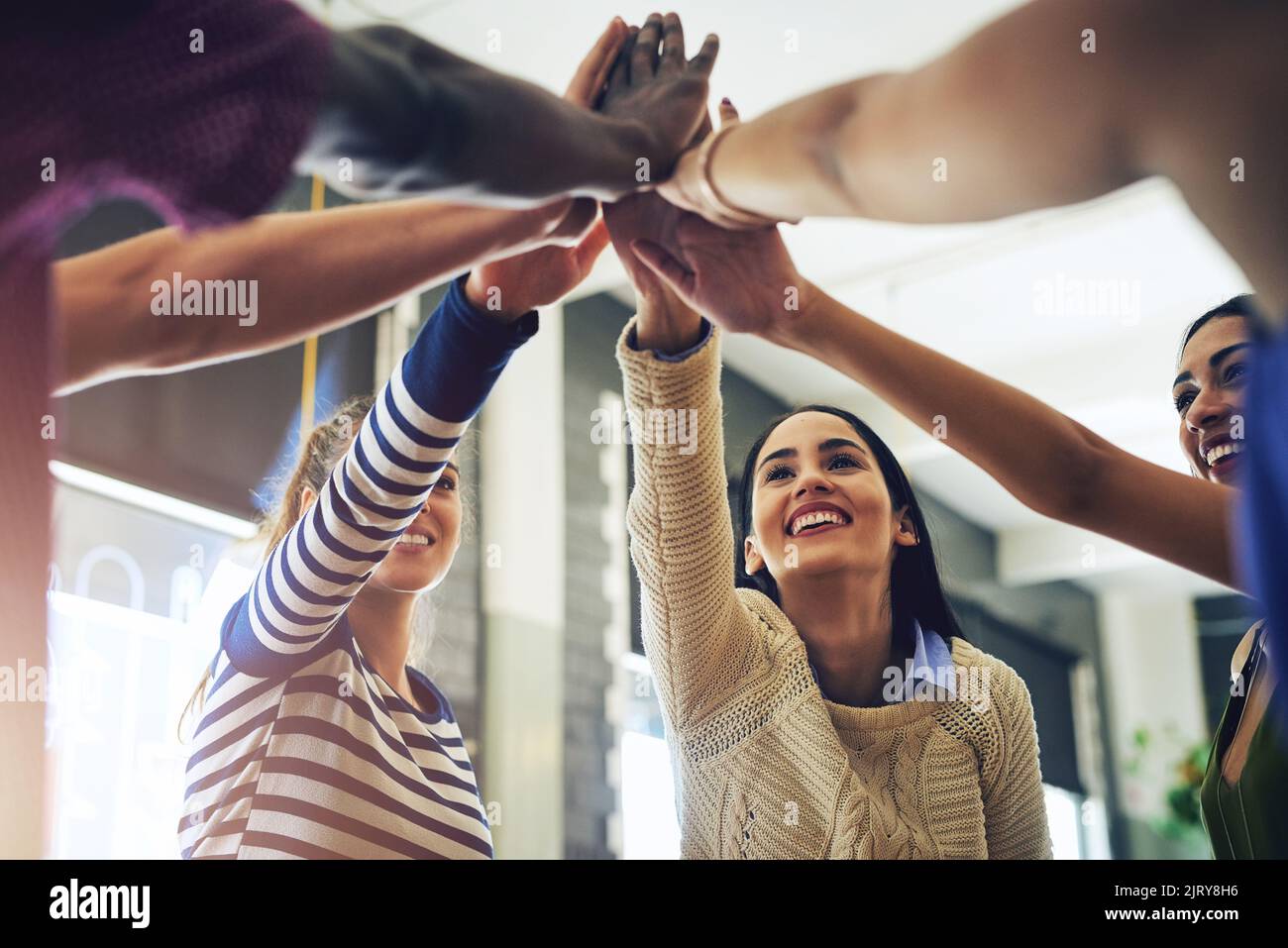 Heres to friendship. Low angle shot of a group of happy friends high ...