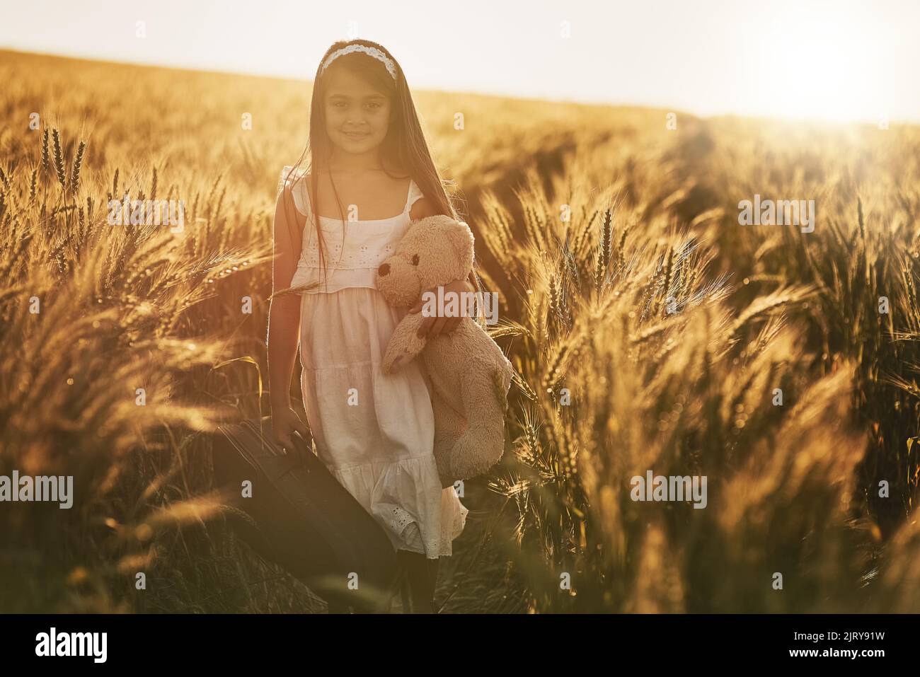 Shes a farm girl at heart. Portrait of a cute little girl playing with her teddybear in a ...