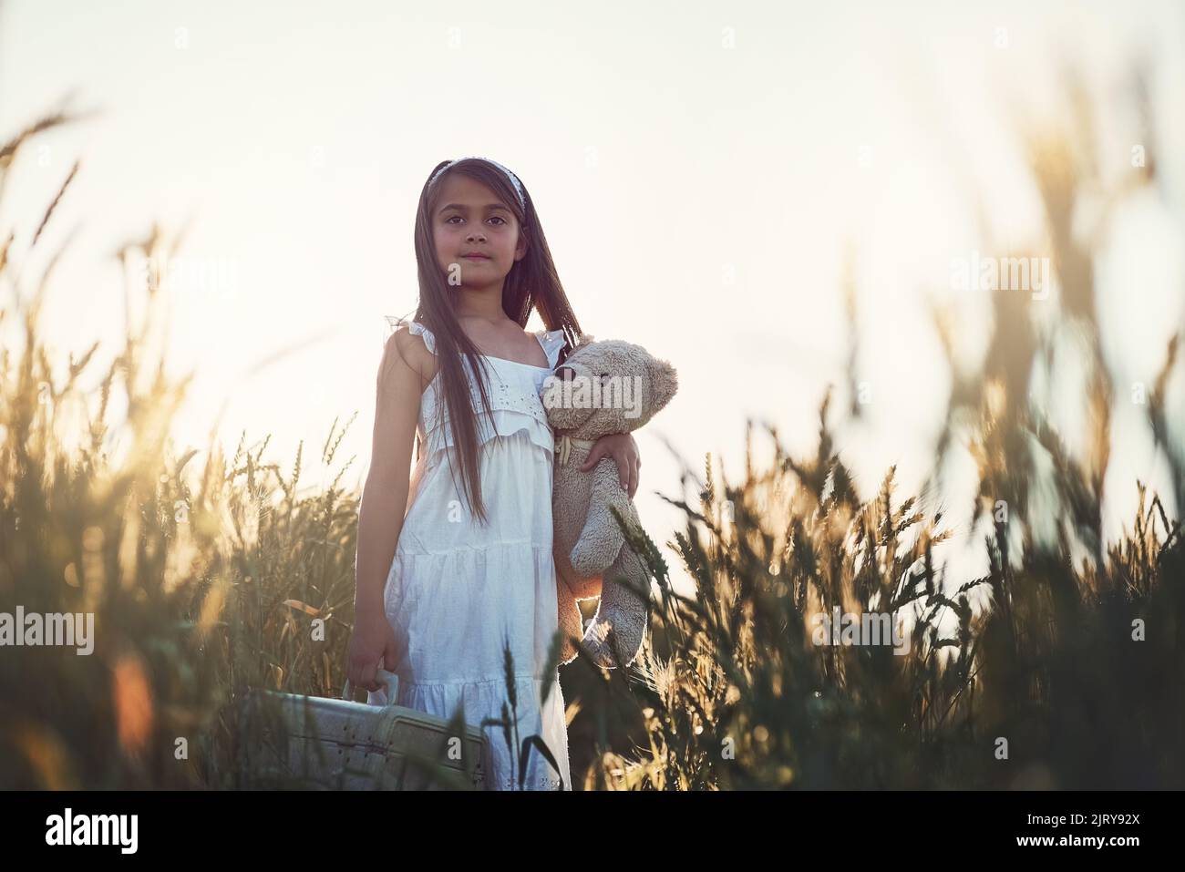 Were ready to leave the farm. Portrait of a cute little girl playing with her teddybear in a ...