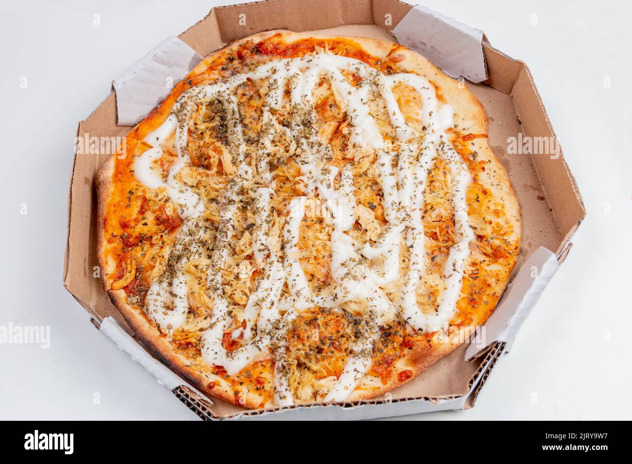 Round chicken pizza with catupiry cheese on a white table. Very common ...