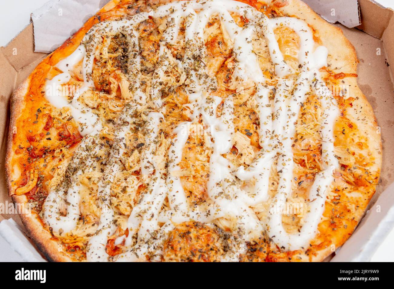 Round chicken pizza with catupiry cheese on a white table. Very common ...