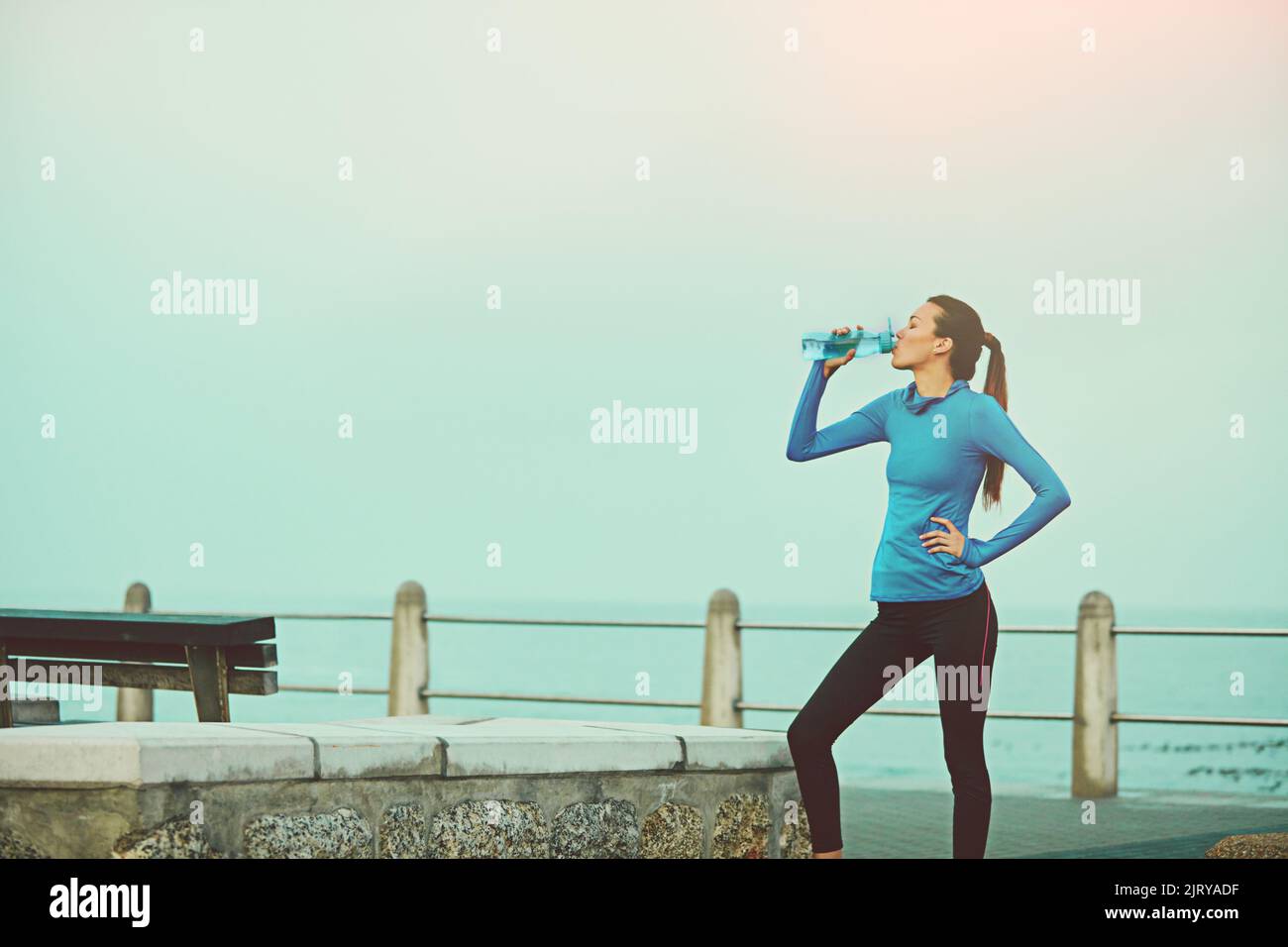 Stay well hydrated while running. a young woman drinking water after ...