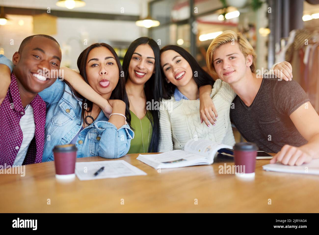 Catching up in the cafeteria. Portrait of a group of happy students ...