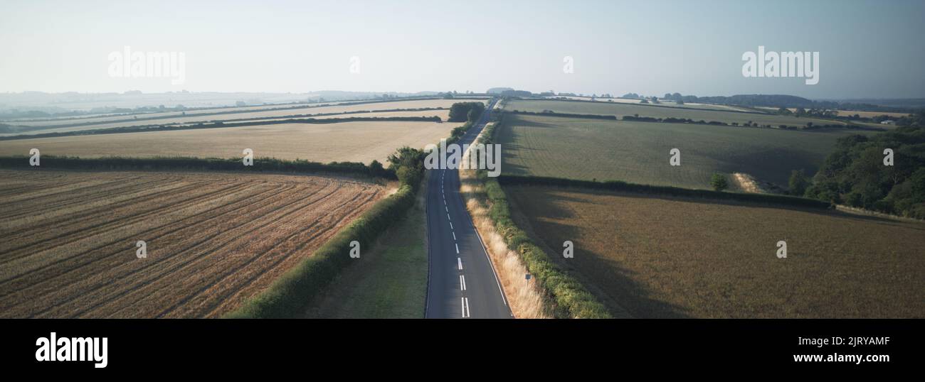 A straight country road in the middle of agricultural fields in ...