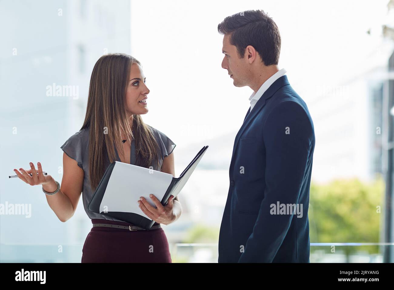 Are you ready for our meeting. two businesspeople having a discussion ...