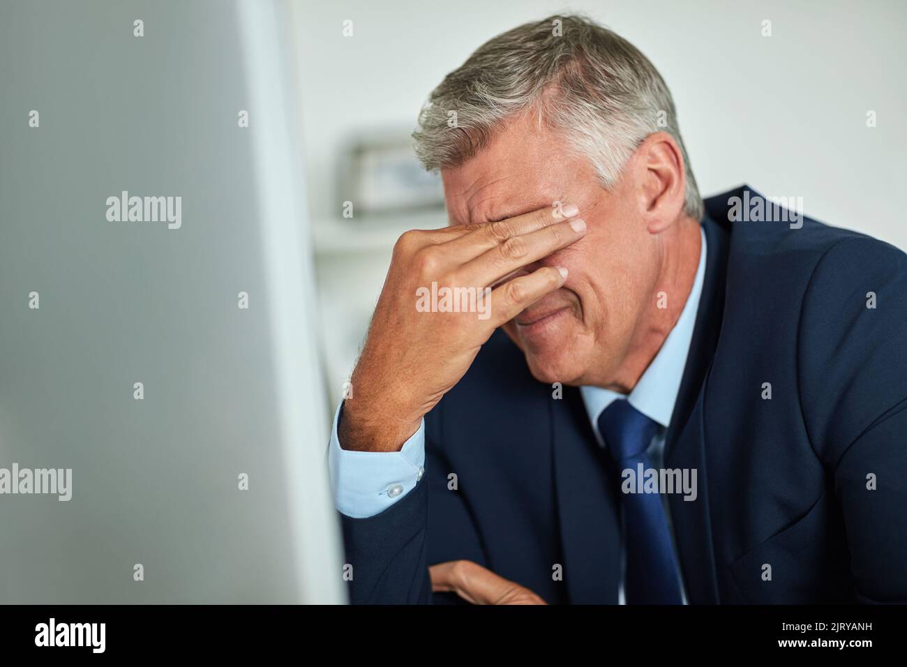 Seriously. a mature businessman looking frustrated while working on his ...