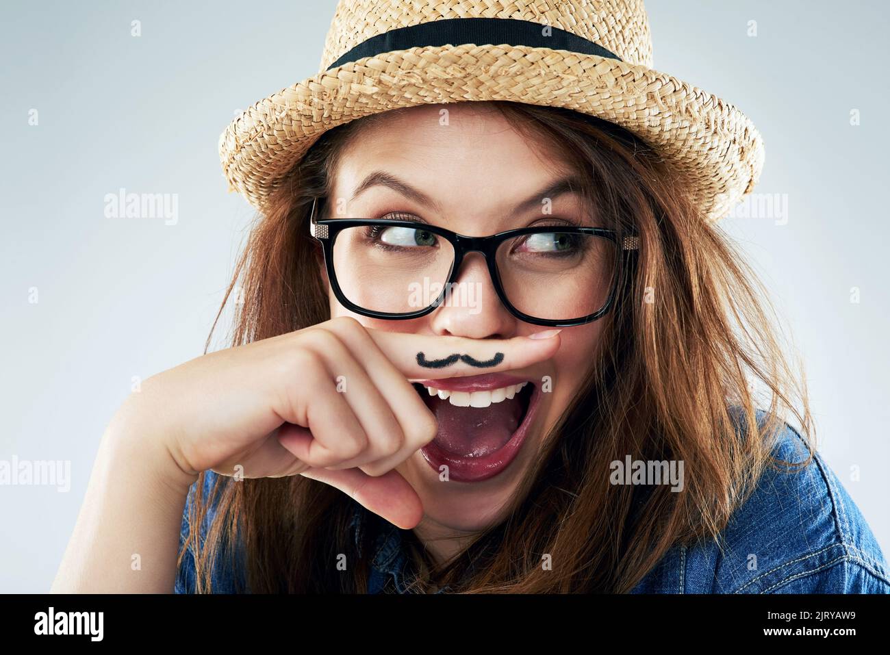Its a flawless disguise. Studio shot of a young woman holding her ...