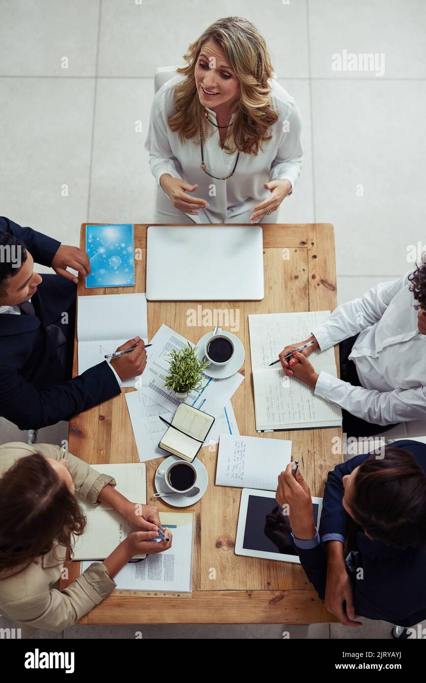 Charting their success. High angle shot of a group of businesspeople ...