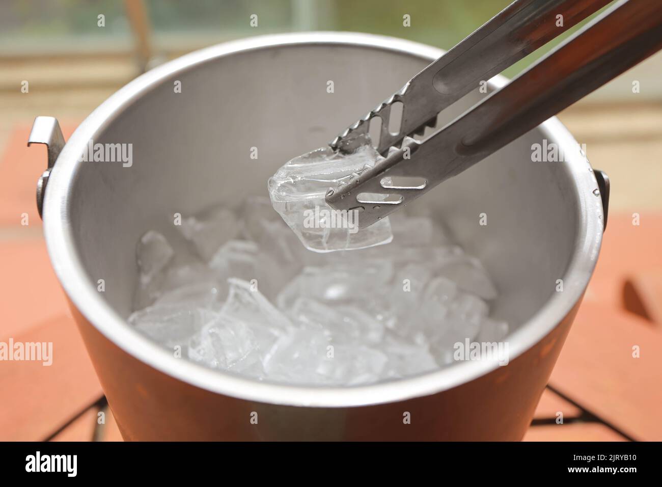 Ice tong used to pick cool ice cubes from steel bucket. concept of ...
