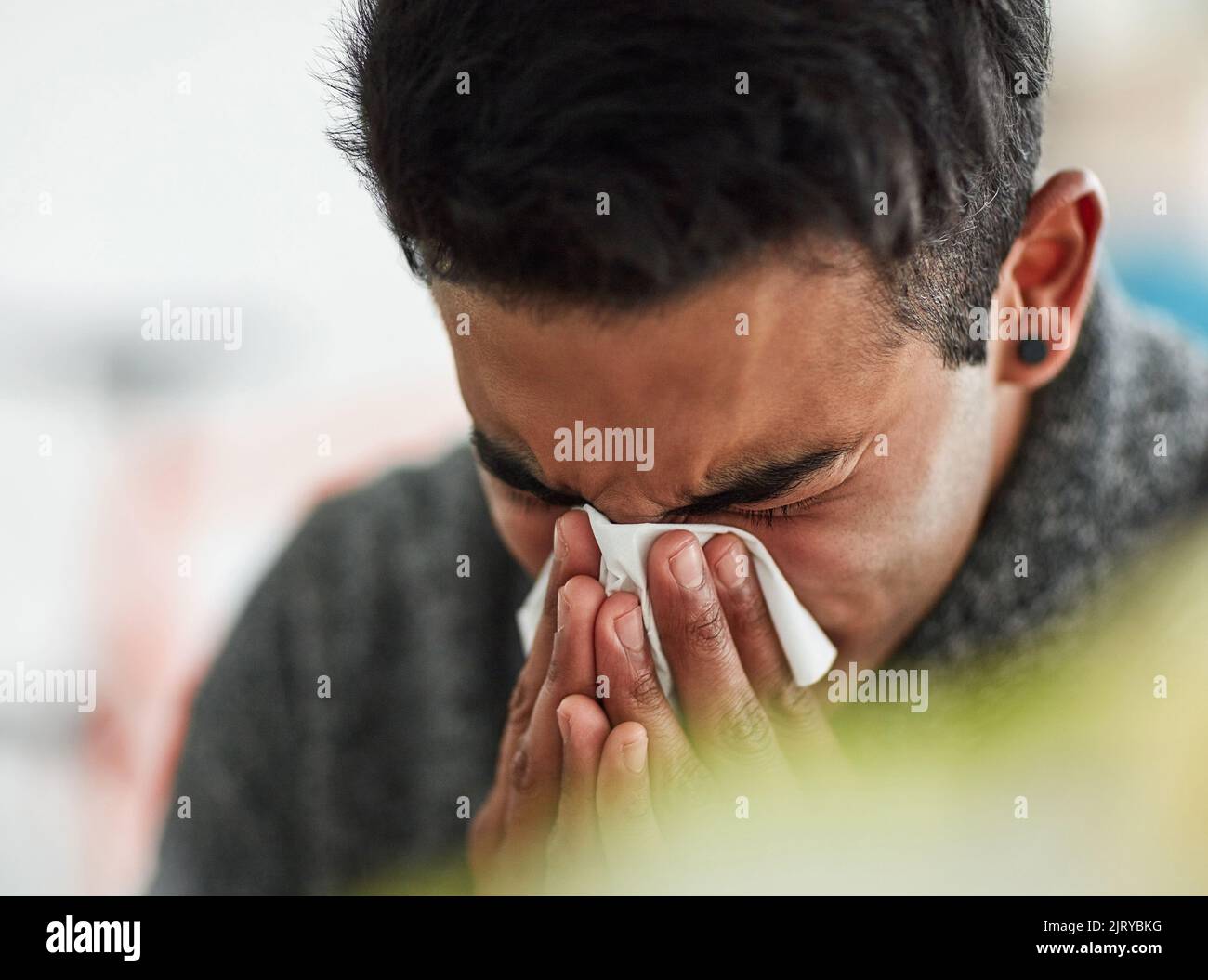 This runny nose is the worst. a young man suffering with allergies ...