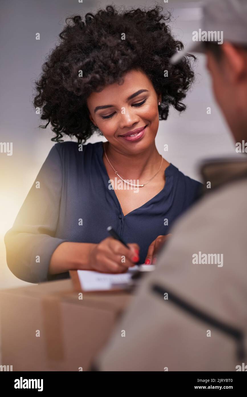 Signing that dotted line. a happy businesswoman signing for a package ...