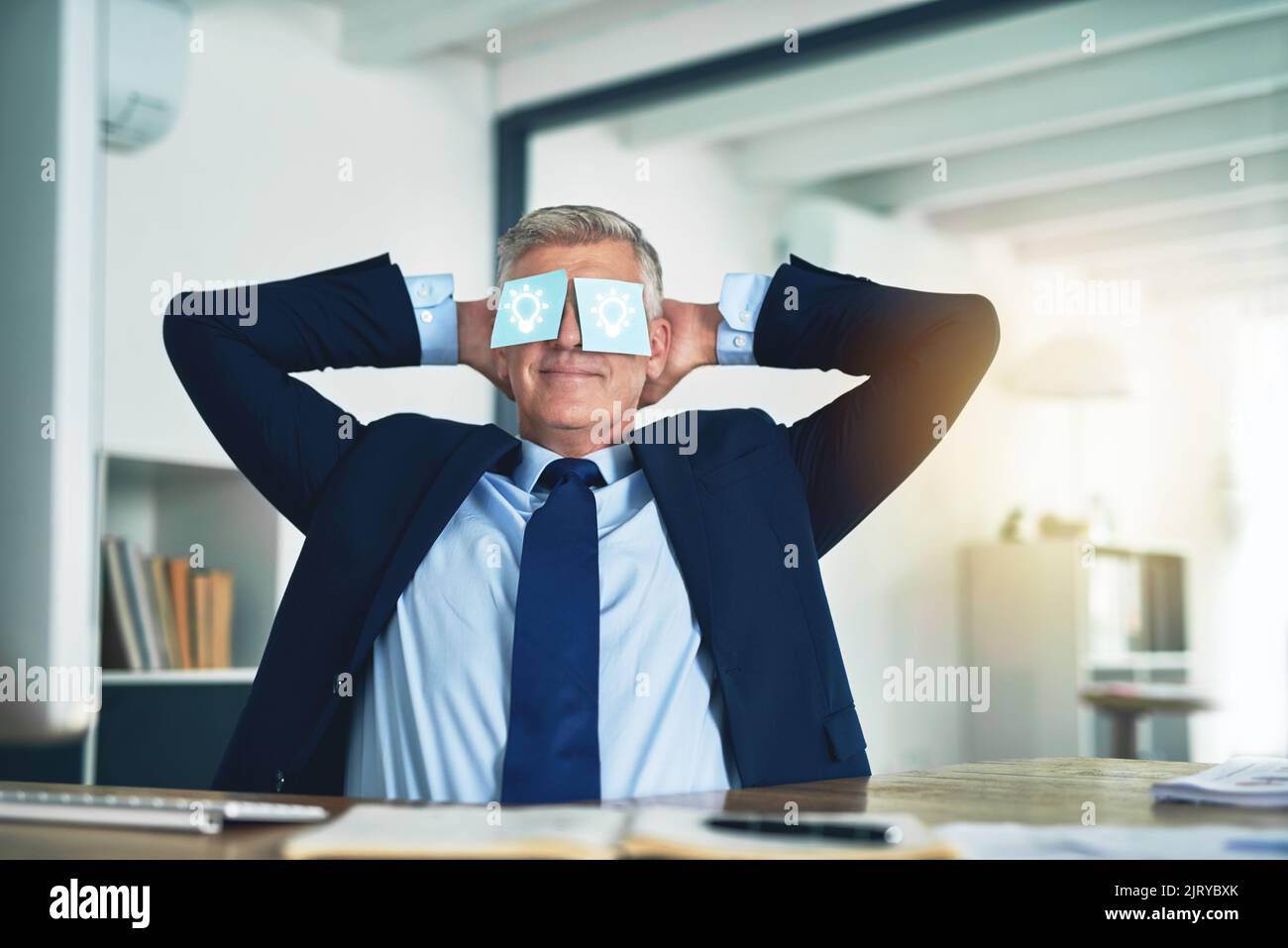 Recharging those brain cells. a businessman relaxing behind his desk ...
