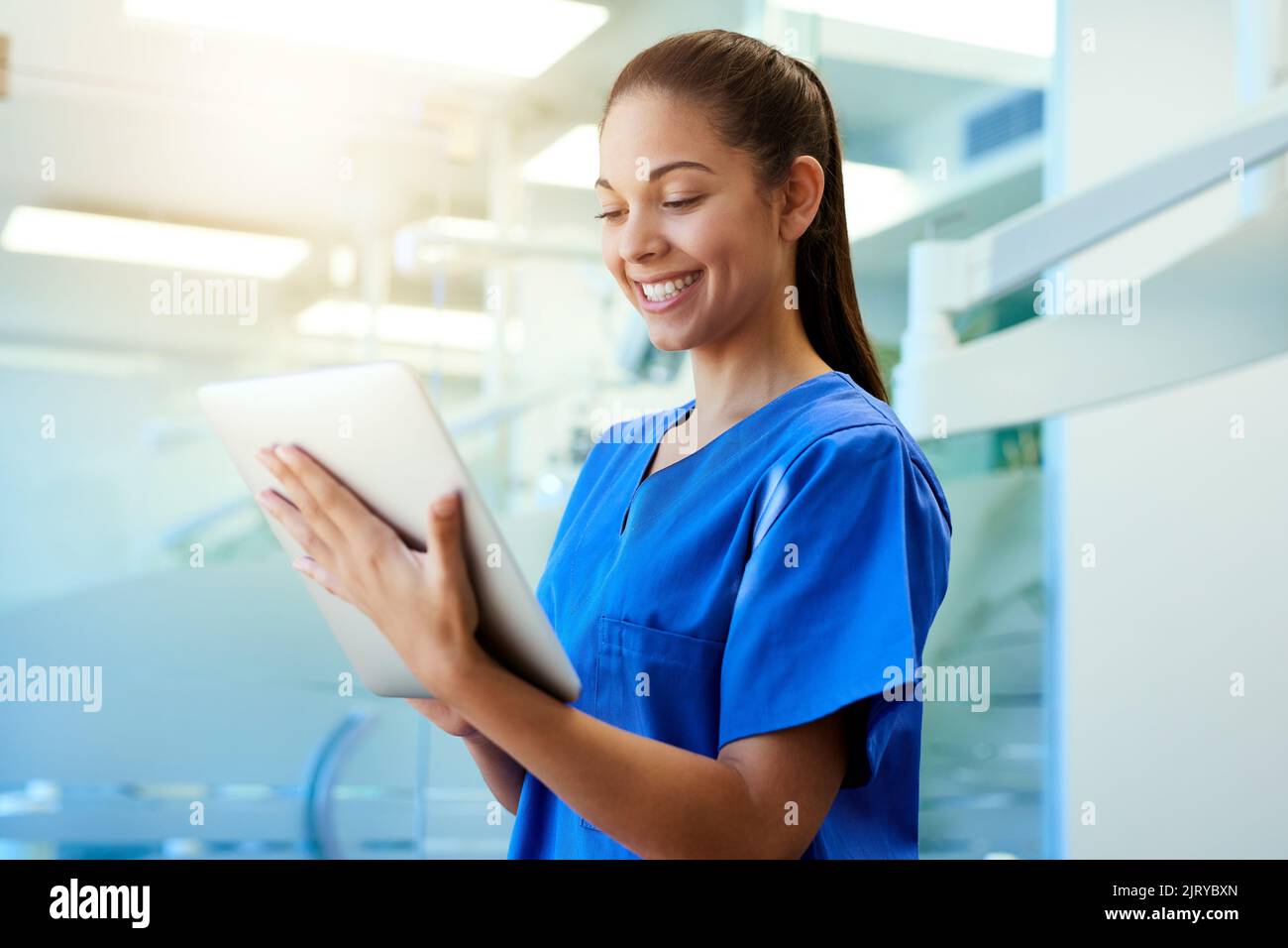Lets ask Dr. Google. a young nurse using a tablet while standing inside ...