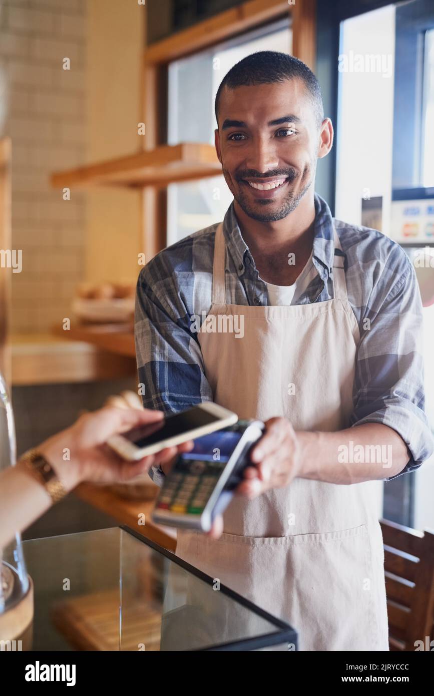 Settle your bill the smart way. a waiter processing a payment from a ...