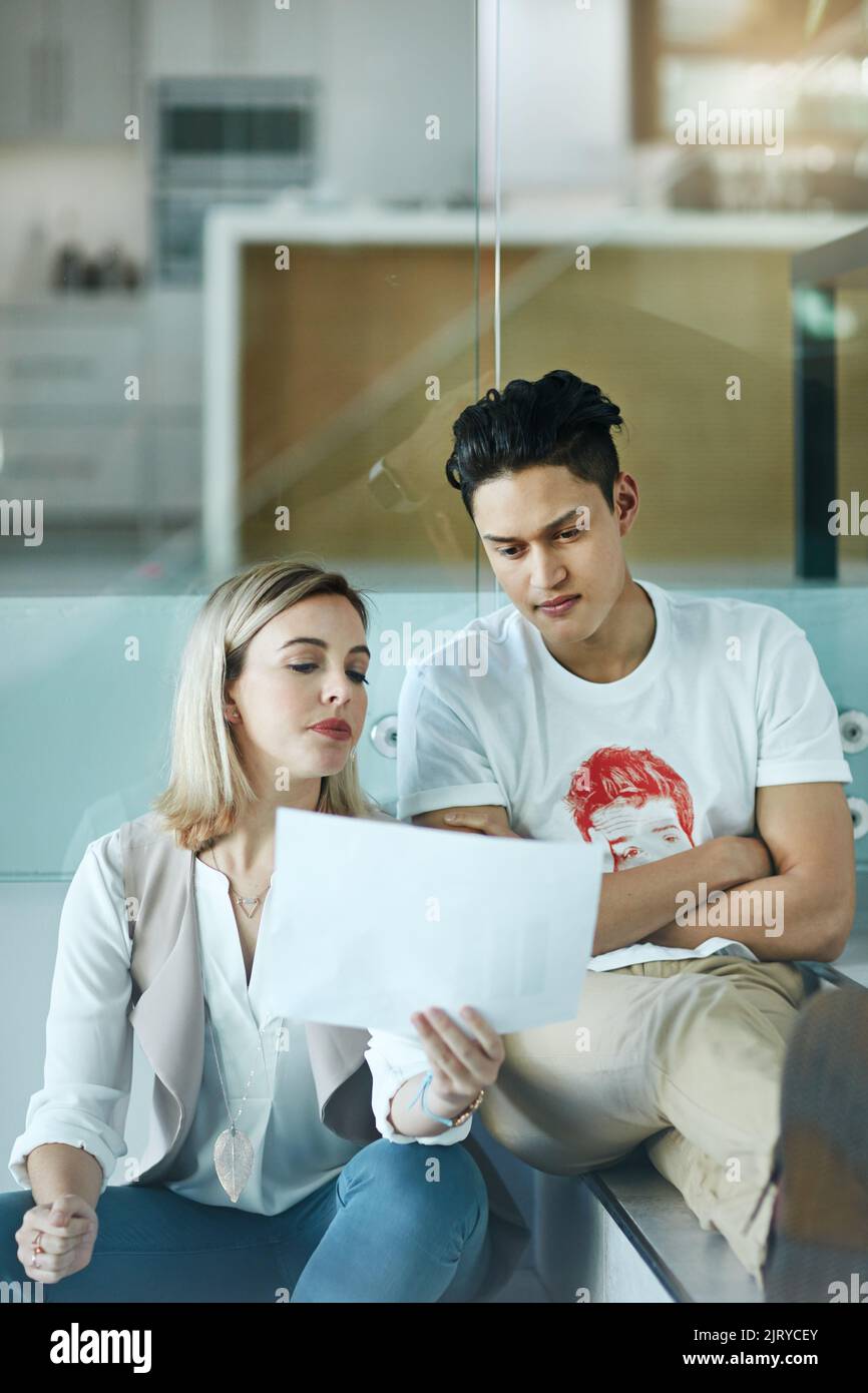 What do you think of it so far. two colleagues reading a document ...