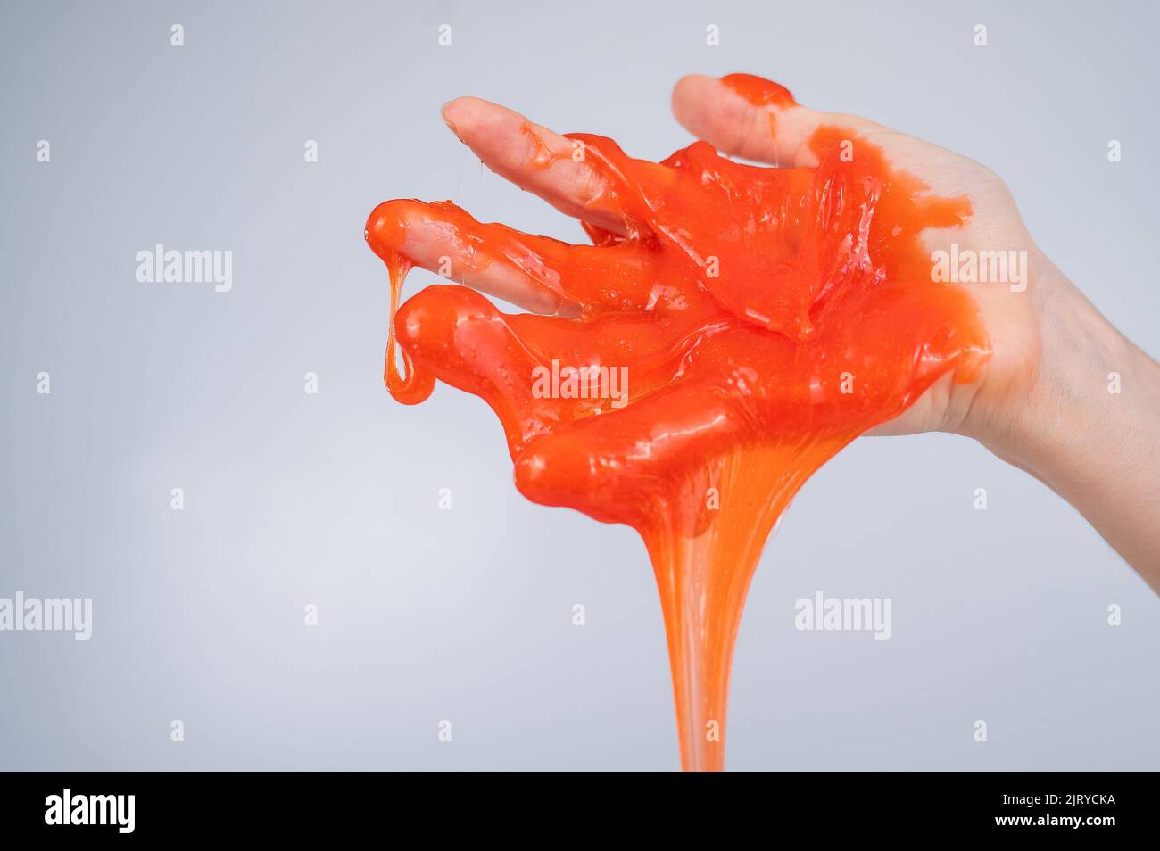 Red slime flowing down from a woman's hand on a white background Stock ...