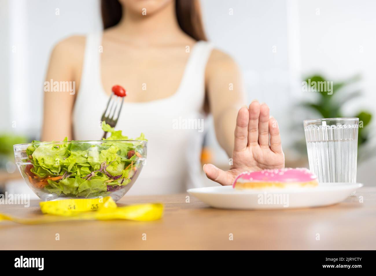 Close up hand of woman stop and using hand push out her favorite donut ...