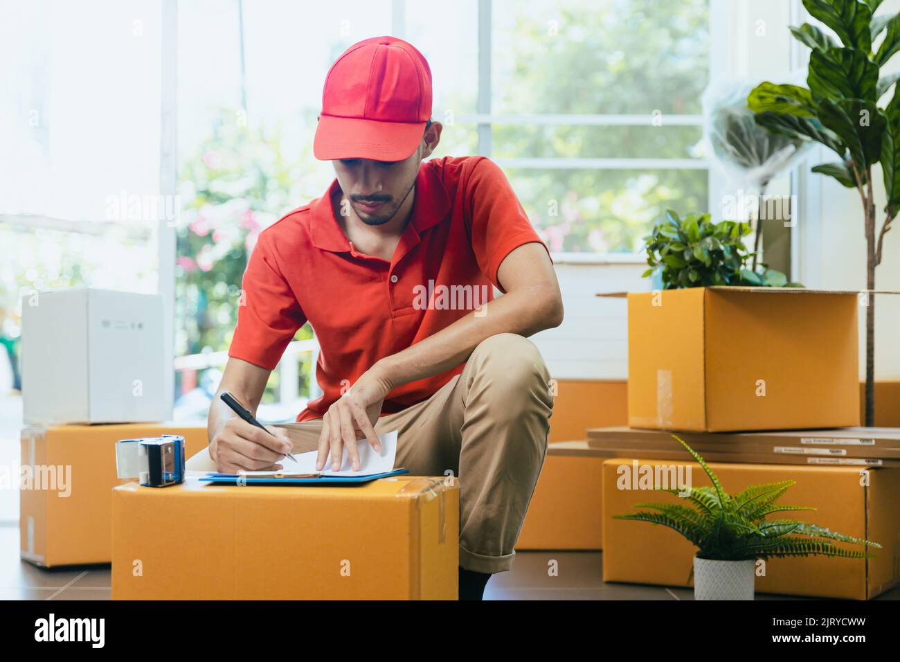 Delivery man checking delivery list before sent to customer Stock Photo ...