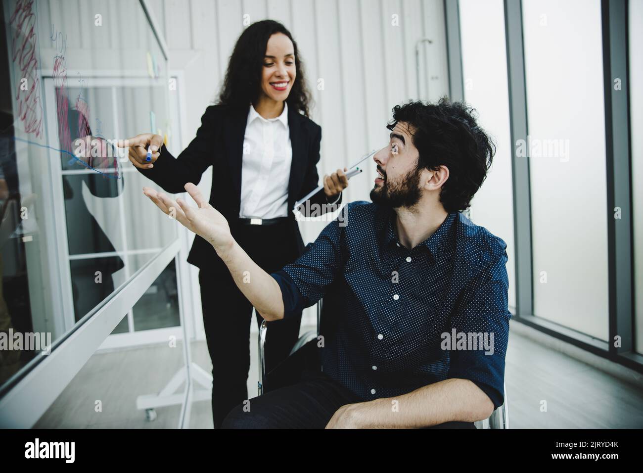 young disabled businessman wearing in wheelchair working and discus ...