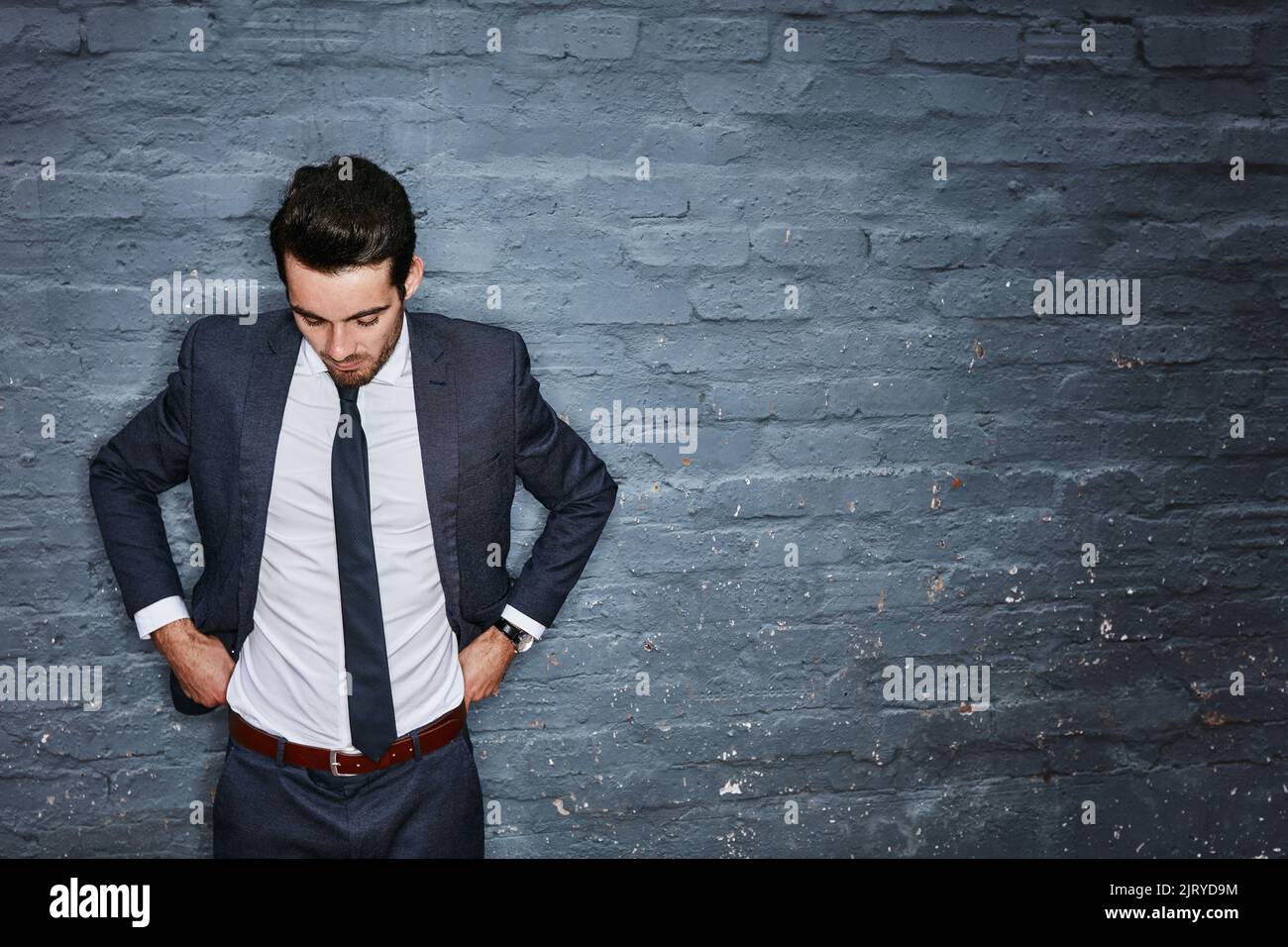 Youve gotta look the part. a businessman adjusting his pants against a ...